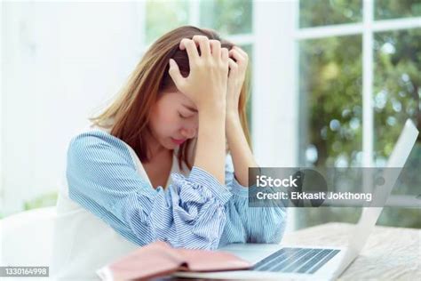 흰색 셔츠를 입은 아시아 여성이 빵집에 앉아 지갑과 노트북으로 스트레스를 받고 머리를 움켜쥐고 있습니다 30 34세에 대한 스톡