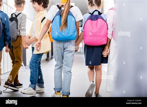 Back View Of Multiethnic Classmates Holding Hands While Walking Along