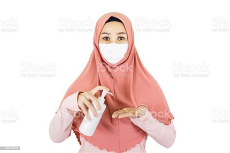 바이러스의 발발 에서 의료 얼굴 마스크를 착용 하는 전통적인 드레스와 젊은 무슬림 아시아 여자 흰색 배경에 고립 된 알코올 젤로