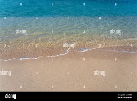 Turquoise Blue Water With Waves Gently Rolling Onto A Sandy Beachcoron