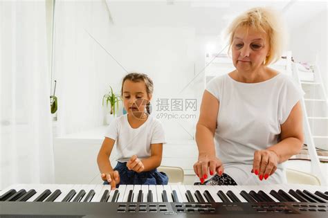 音乐老师教女孩如何弹钢琴高清图片下载 正版图片505603414 摄图网