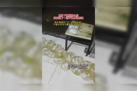 屋外下暴雨积水后男子想了一招不让水进店 以水治水积水男子暴雨