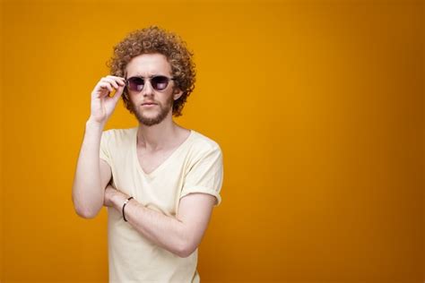 Free Photo Cheerful Naked Man In Shorts And Unusual Sunglasses Holding Cocktail While Pointing