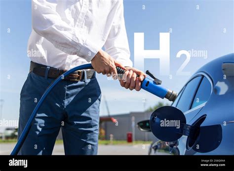 Man Holds A Hydrogen Fueling Nozzle On A Hydrogen Filling Station