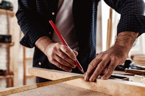 Premium Photo Carpenter Makes Pencil Marks On A Wood Plank