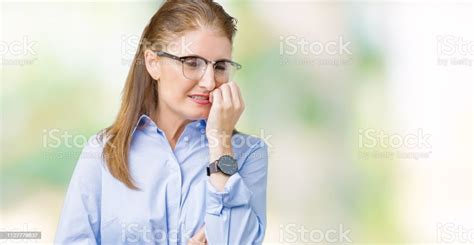 아름 다운 중간 나이 성숙한 비즈니스 여 자가 입을 물고 손톱에 손으로 스트레스와 긴장을 찾고 고립 된 배경 위에 안경을 착용 불안 문제 갈색 머리에 대한 스톡 사진 및