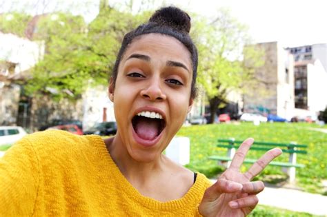 Premium Photo Excited Young Woman Taking Selfie With Peace Sign