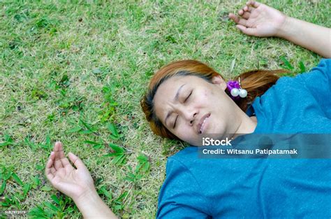 Young Asian Woman Fainting On Grass In Park Because Outdoors Of Hot