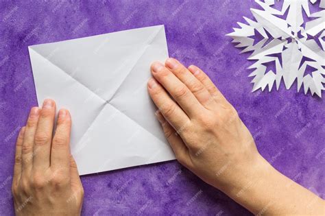 Premium Photo Woman Hands Holding Square Sheet Of Paper With Marked