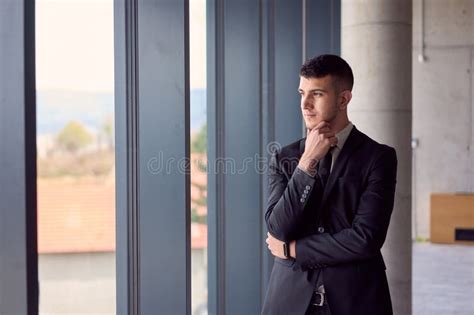 The Confident Businessman In A Sleek Suit Strikes A Pose Exuding