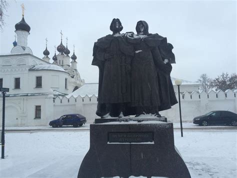 A Statue In Front Of A White Building With Snow On The Ground
