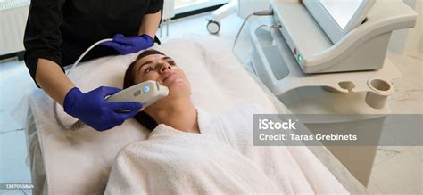 웰빙 스파 미용 클리닉에서 현대적인 레이저 장비로 얼굴에 노화 방지 치료를받는 아름다운 중년 여성 건강 관리 및 의학 미용 치료
