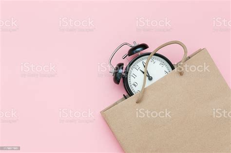 분홍색 배경에 공예 패키지에 검은 알람 시계 컨셉 블랙 프라이데이 시즌 세일 시간 평면 누워 맨 위 보기 복사 공간 설계에 대