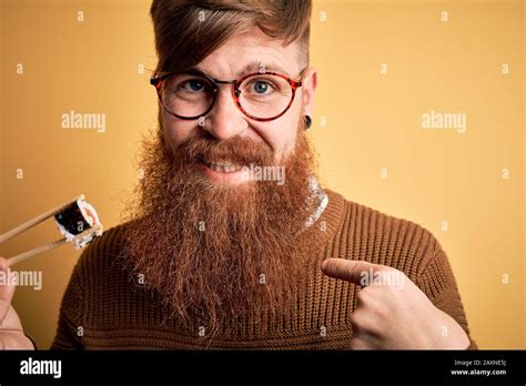 Redhead Irish Man With Beard Eating Salmon Maki Sushi Using Chopsticks