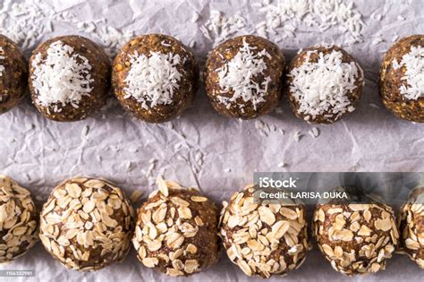 날짜 자두 건포도 땅콩 귀리 플레이크 말린 크랜베리 피칸 견과류 코코넛 면도 흰색 요리 용지 배경으로 만든 건강한 유기농 에너지 공 0명에 대한 스톡 사진 및 기타 이미지