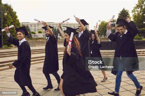 대학 건물 배경을 통해 손을 들고 걷는 행복한 졸업생 그룹 대학교에 대한 스톡 사진 및 기타 이미지 대학교 소년 이주