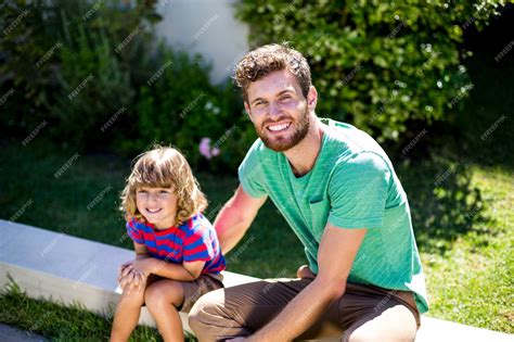 Premium Photo Father With Son Sitting In Backyard
