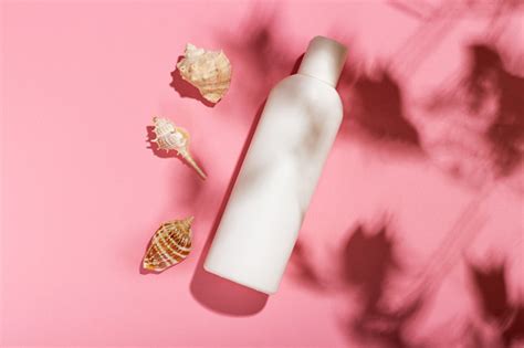 조개와 그림자가 있는 분홍색 배경에 얼굴 크림이나 로션 텔라나를 곁들인 화이트 코스메틱 보틀 선 크림 여름 화장품 메이크업 화장품에 대한 스톡 사진 및 기타 이미지 Istock