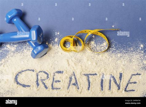 Word Creatine Written On Creatine Powder On Blue Background With