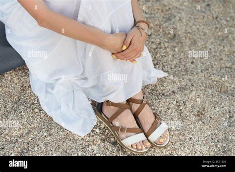Top View Of Woman In Long White Dress Sitting On Sandy Beach And