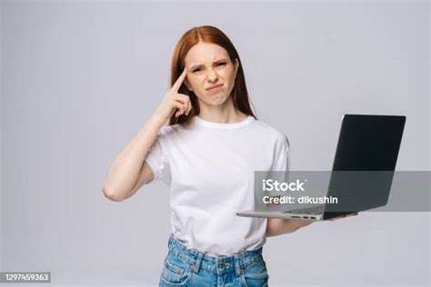 혼란 젊은 비즈니스 여성 또는 학생 들고 열어 노트북 컴퓨터와 몸짓 가리키기에 대한 스톡 사진 및 기타 이미지 가리키기