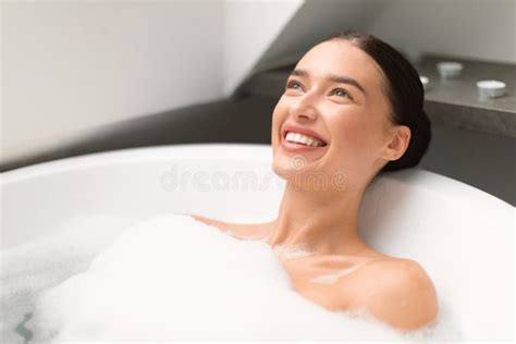 Cheerful Lady Taking Bath Lying In Foam Bubbles In Bathroom Stock Image