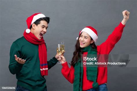 회색 고립 된 스튜디오 배경에서 크리스마스를 축하하는 샴페인을 마시는 다채로운 빨간색과 녹색 옷을 입은 행복한 흥분 아시아 커플 20 24세에 대한 스톡 사진 및 기타