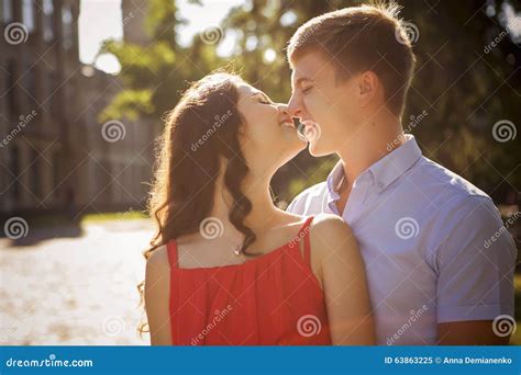 Beautiful Brunette Couple In Love Kissing On A Date In The Park Stock