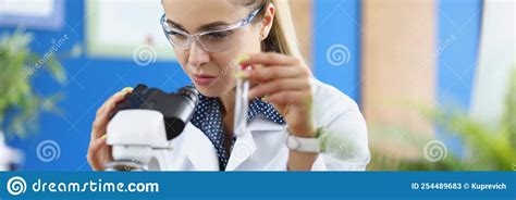 Woman Scientist Chemist Looking Through Microscope And Holding Test