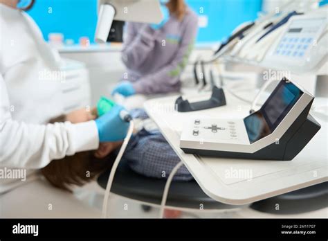Dentist Treats The Patient On Modern Equipment Uses A Microscope Stock