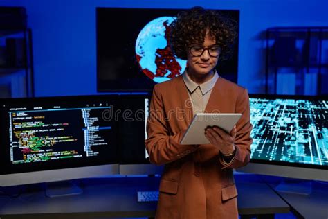 Young Serious Female Programmer Using Tablet Against Computers Stock