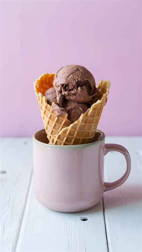 Waffle Cone With Chocolate Ice Cream In Pink Mug On White Surface Stock