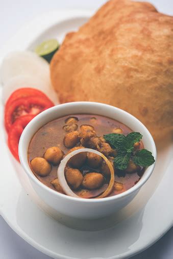 Chole Bhature 또는 병아리 완두콩 카레와 튀김 푸 리 흰색 배경 위에 테라코타 그릇에 제공 됩니다 선택적 초점 0명에