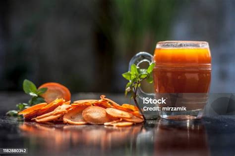 나무 표면에 신선한 당근 주스가 담긴 유리 잔과 당근 조각 테이블에 있는 멘타 잎이 있습니다 흐린 배경이 있는 수평 촬영 가리기에 대한 스톡 사진 및 기타 이미지 Istock