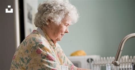 노란색과 녹색 꽃 셔츠를 입은 여자 흰색 세라믹 머그잔을 들고 있다 사진 Unsplash의 무료 고령자 이미지