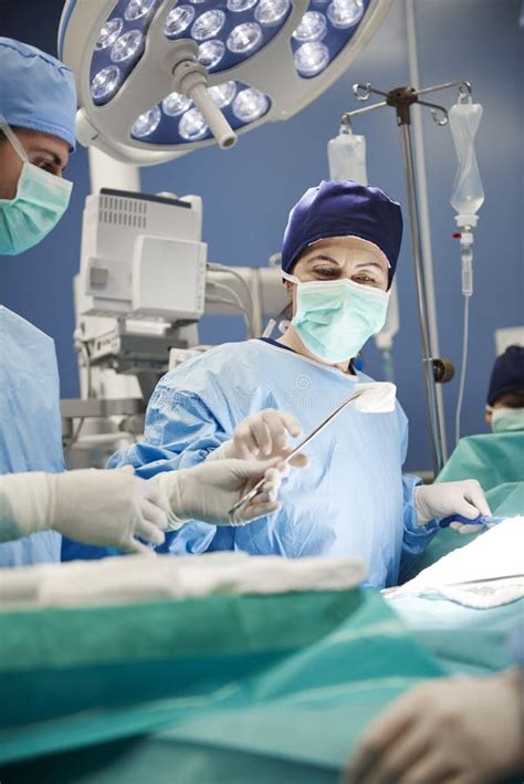 Surgeons Passing Scissors To Each Other During An Operation Stock Image