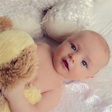 Beautiful Naked Baby With Big Blue Eyes Lying On The Bed With Toys Stock Photo Adobe Stock