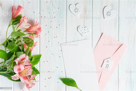 빈 종이와 흰색 색상의 자연 꽃 어두운 나무 배경에 봉투를 모의 빈 텍스트 프레임입니다 꽃과 인사말 카드 디자인입니다 배경 평면