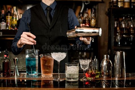 Professional Bartender Holds Steel Shaker And Mixes Cocktail Stock