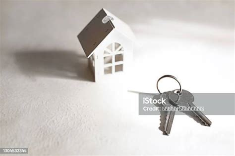 회색 배경에 흰색 목조 주택 기호와 열쇠 코티지 건설 개념 레이아웃 및 디자인 건축 계획 새로운 집 부동산 준비 사업으로 이동