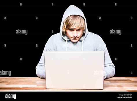 Man In Hood Jacket Hacking A Laptop Stock Photo Alamy
