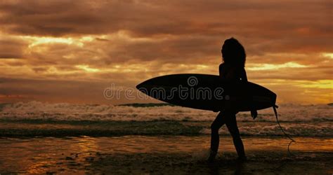 Sunset Silhouette And Woman With A Surfboard Beach And Water With