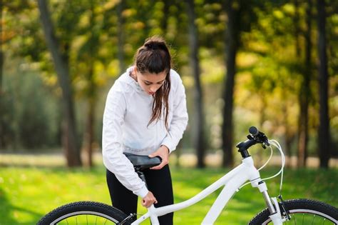 Linda garota posando em bicicleta branca ande na natureza Foto Grátis