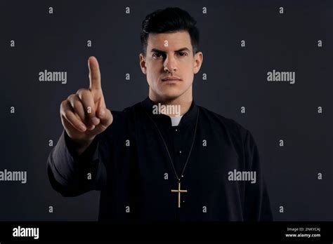 Priest Wearing Cassock With Clerical Collar On Black Background Stock