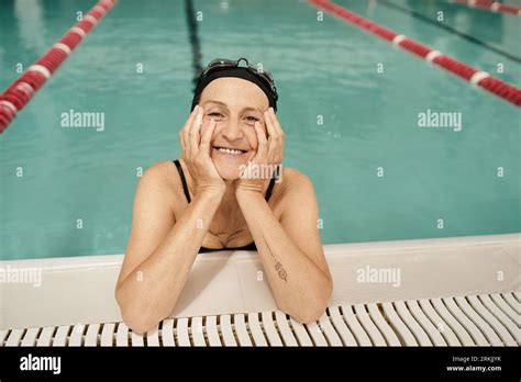 Joyous Middle Aged Woman In Swim Cap And Goggles Looking At Camera