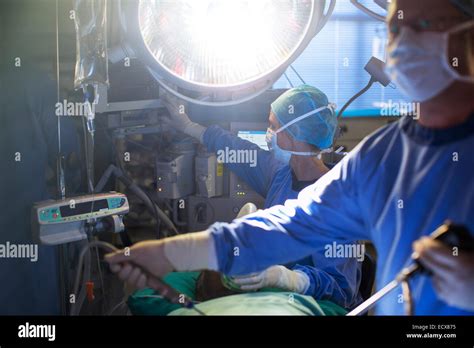 Male And Female Surgeons Performing Laparoscopic Surgery In Operation