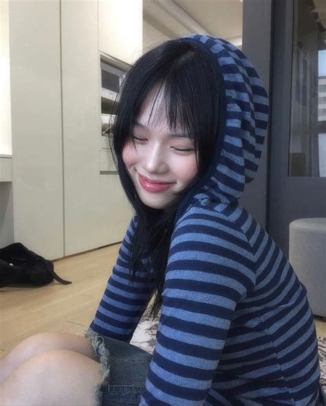 A Woman Sitting On The Floor With Her Eyes Closed Wearing A Blue And