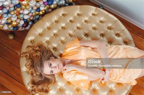 둥근 Pouf에 누워 복숭아 실크 가운에 아름 다운 금발 여자 상단에서 보기 높은 각도 감정에 대한 스톡 사진 및 기타 이미지