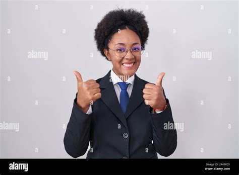 Wunderschöne afrikanische Frau mit lockigem Haar eine Geschäftsjacke und eine Brille trägt