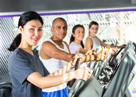 People Having Running Elliptical Trainer Class In Club Stock Image